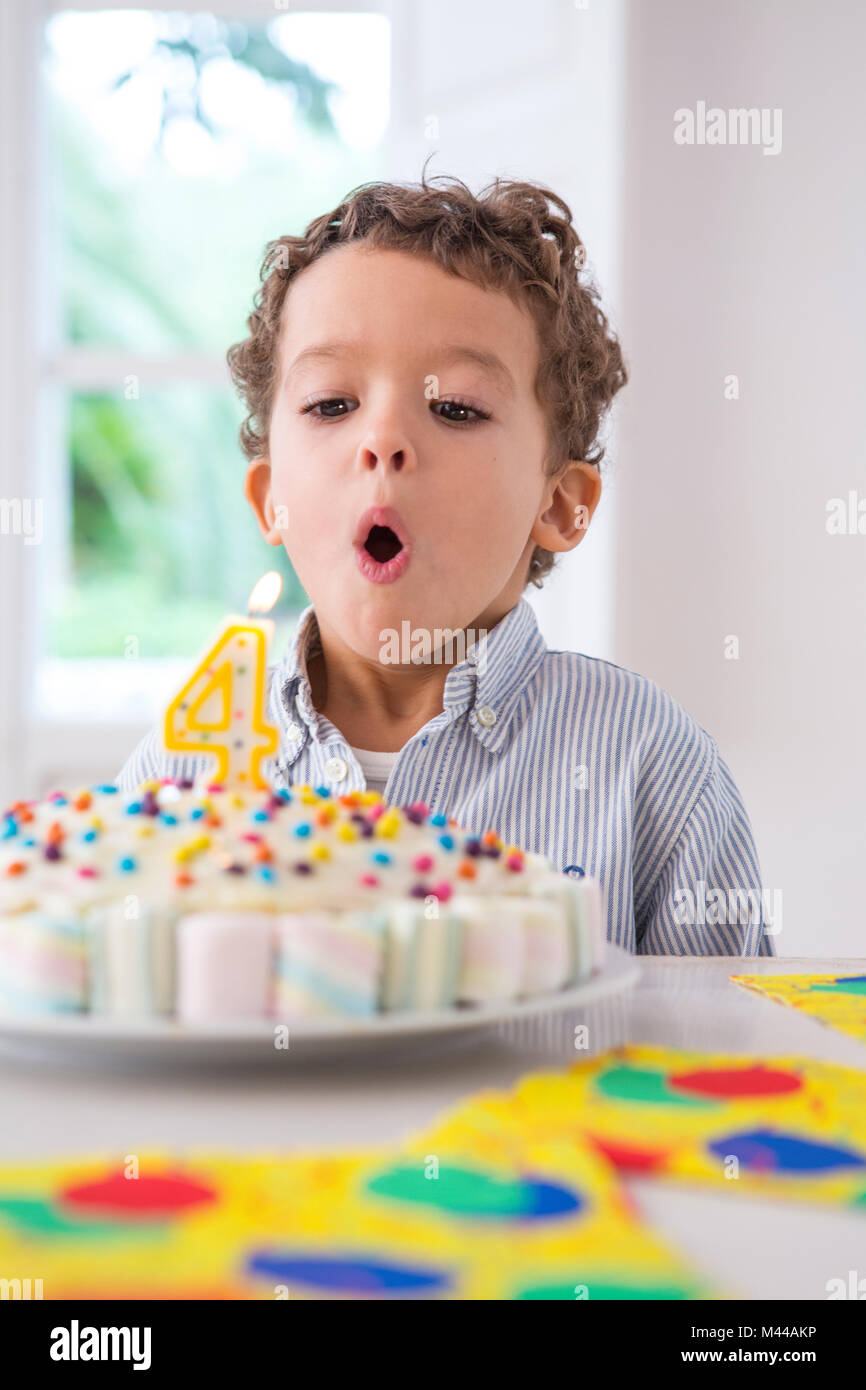 Boy blowing out candles on birthday cake Stock Photo - Alamy