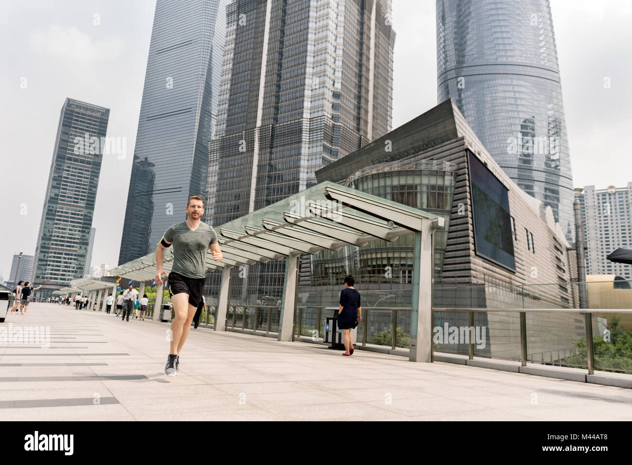 Young male runner running in Shanghai financial centre, Shanghai, China ...