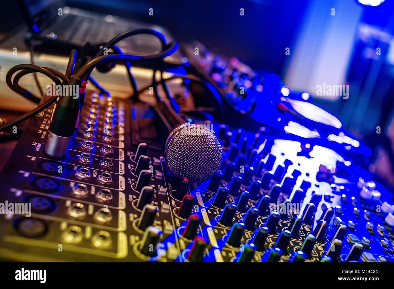 Detail of a sound mixer with a microphone and a laptop with a club ...