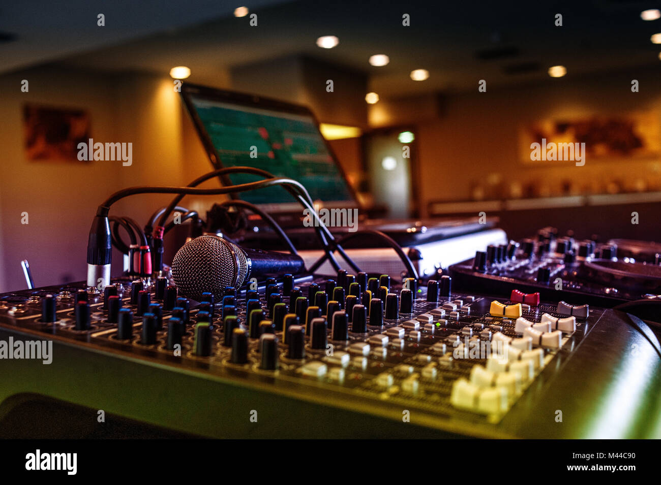 Detail of a sound mixer with a microphone and a laptop with a club ...
