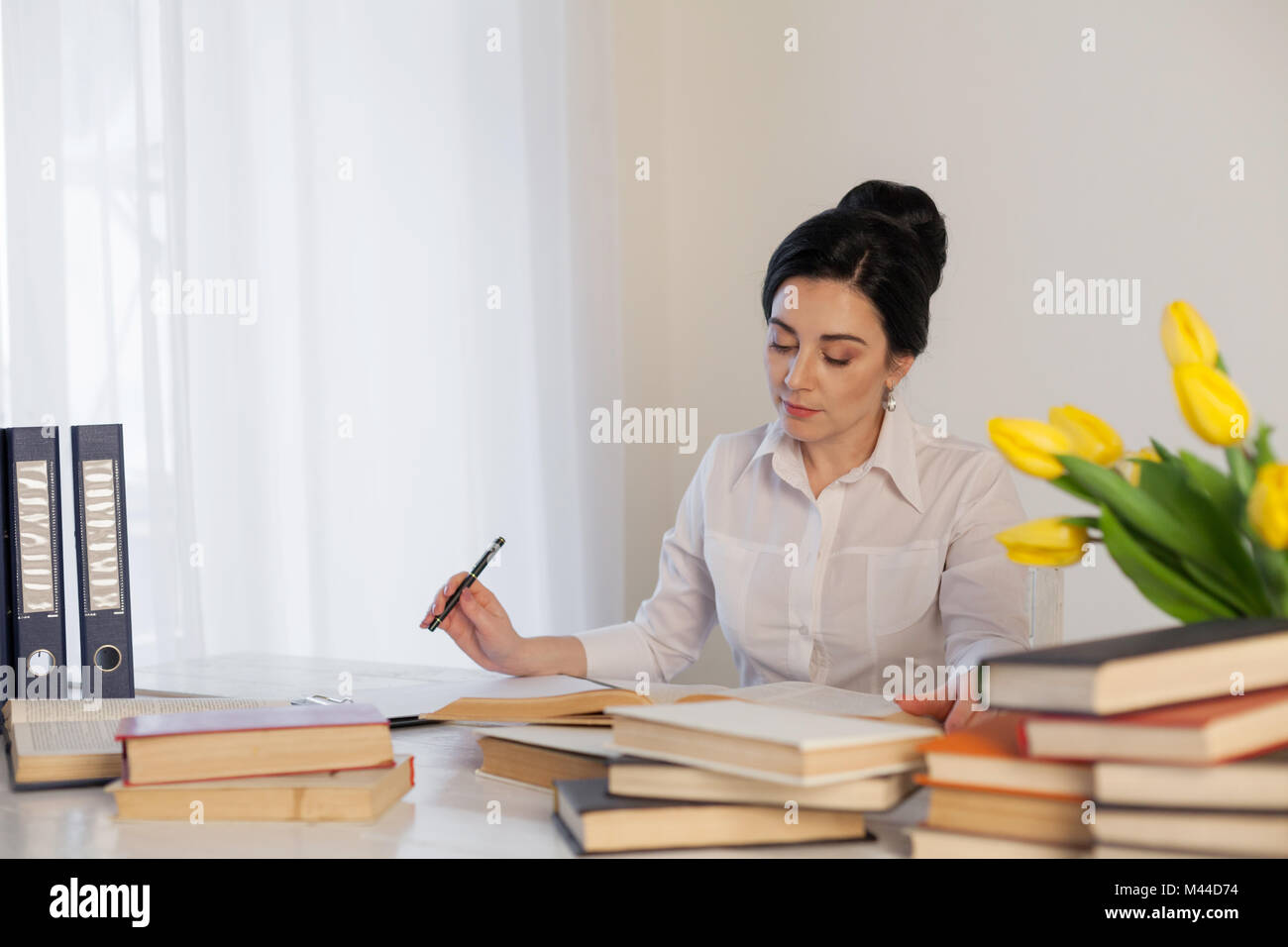 girl reading book at the table in the Office business Stock Photo - Alamy