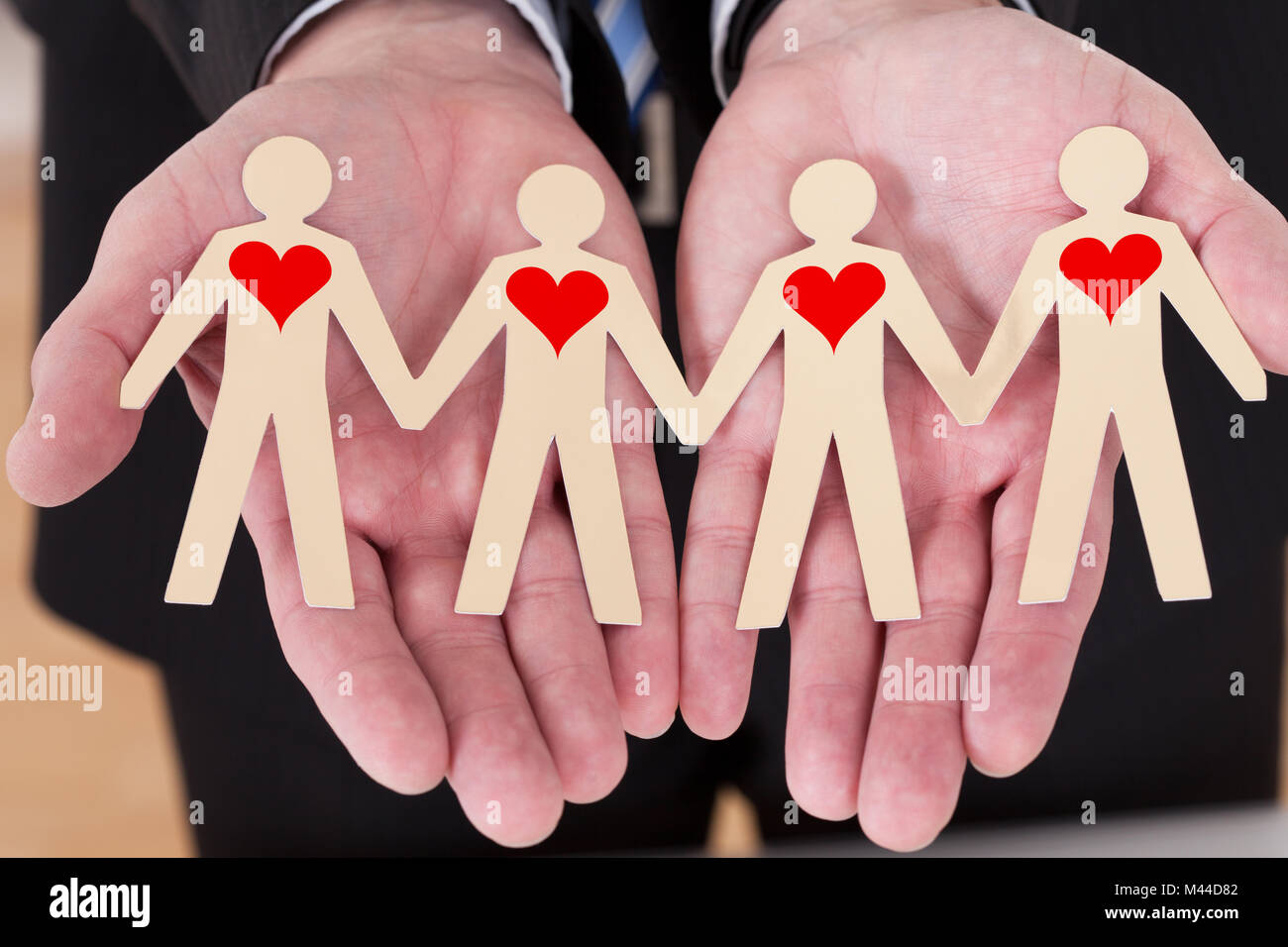 Close-up Of Man's Hand Showing Paper Cut Out Figures With Heart Shape ...
