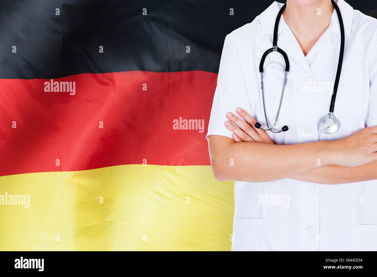 Close-up Of A Female Doctor With Folded Hands Standing Against German ...