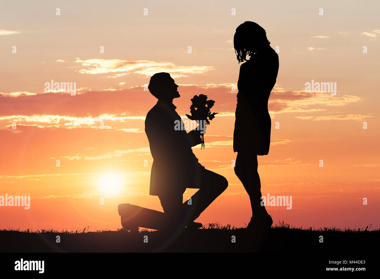 Silhouette Of A Man Proposing His Girlfriend Against Dramatic Sky At ...