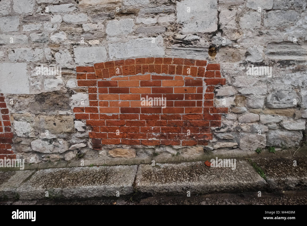 Stone wall with bricked-in arch Stock Photo - Alamy