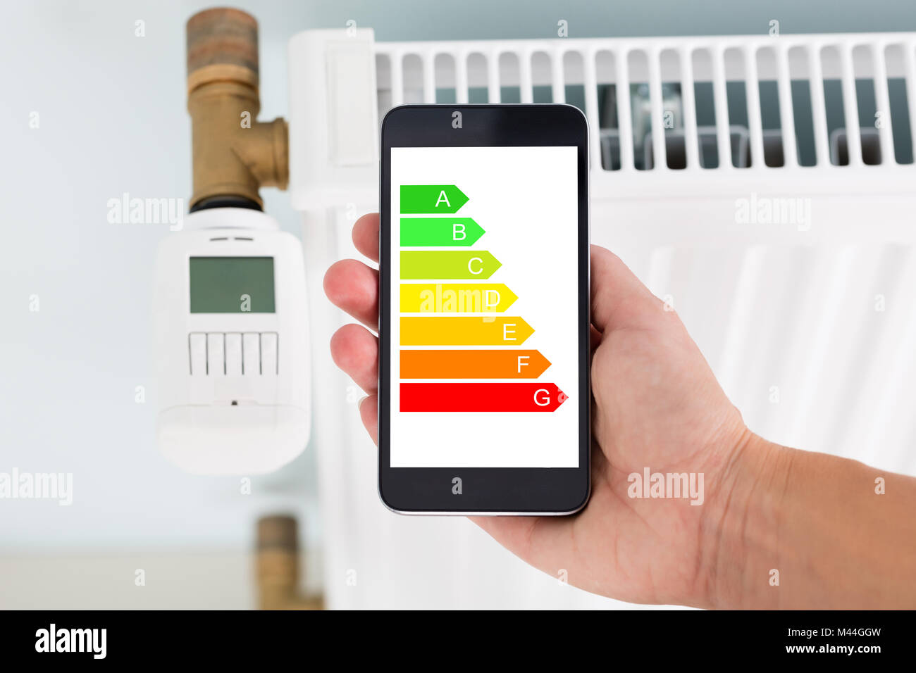 Closeup of man's hand using energy label on mobile phone against ...