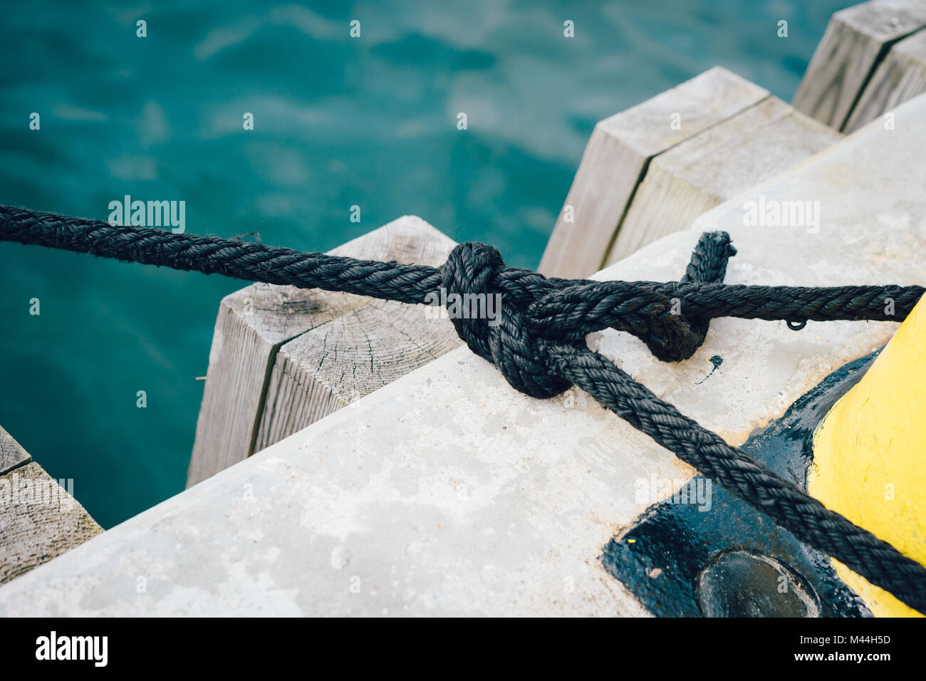 Mooring rope tied around a bollard on a pier Stock Photo - Alamy