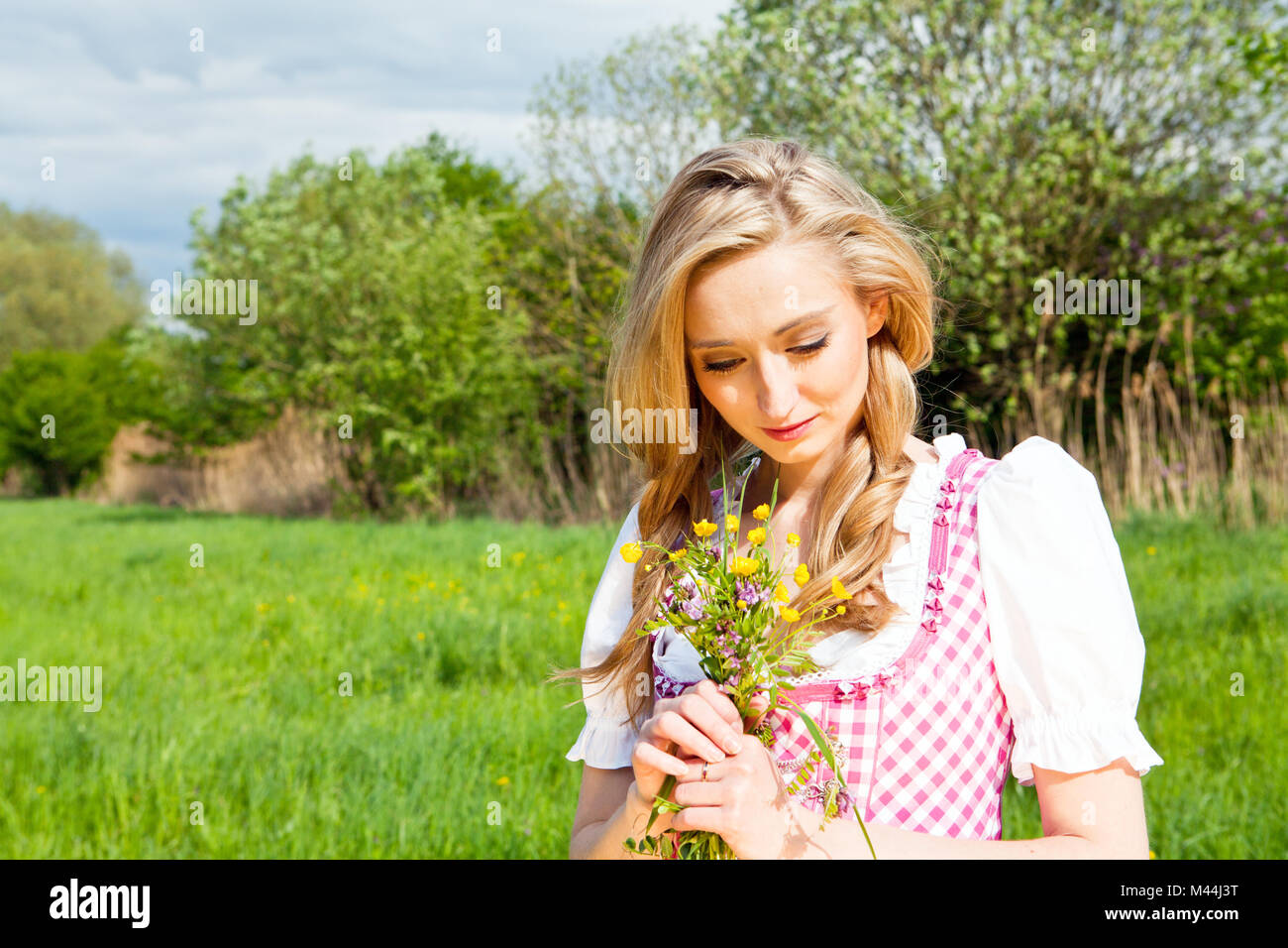 Young beautiful girl with pink dirndl outside Stock Photo - Alamy