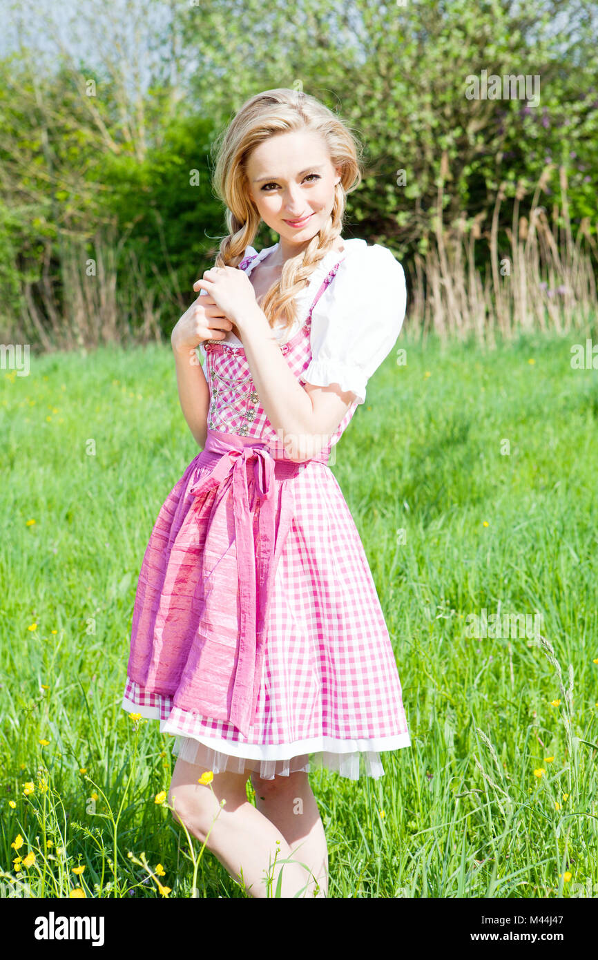 Young beautiful girl with pink dirndl outside Stock Photo - Alamy