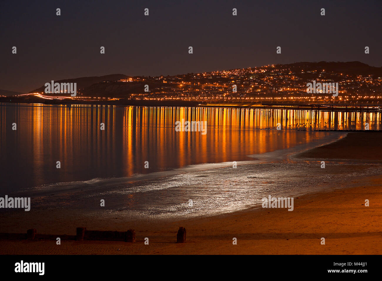 Streetlights reflecting in the sea at Colwyn Bay at night on the North ...