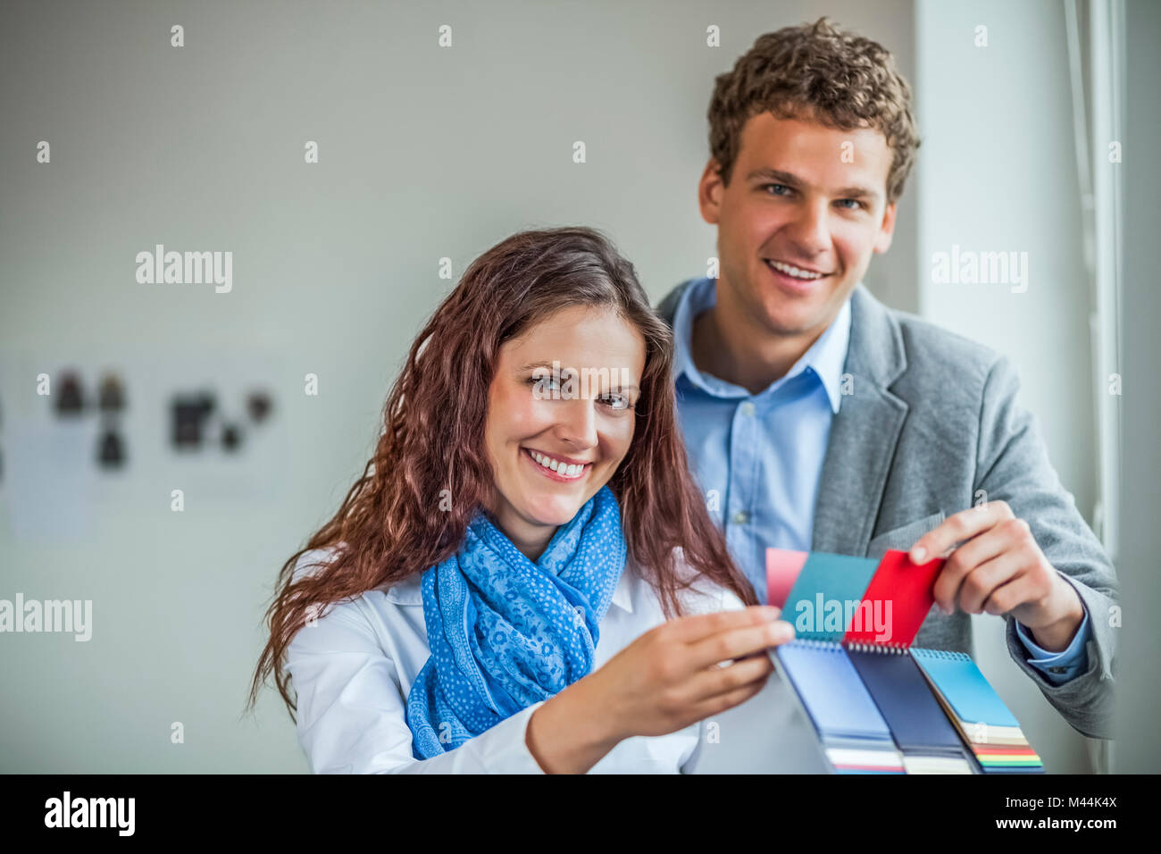 Portrait of young business people choosing color from swatches in ...