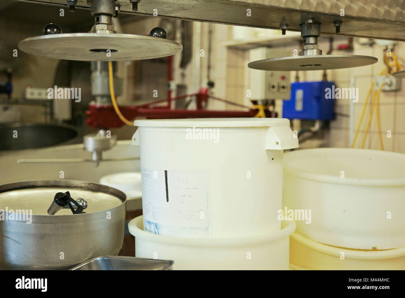 white empty containers waiting by the cheese press to be filled with ...