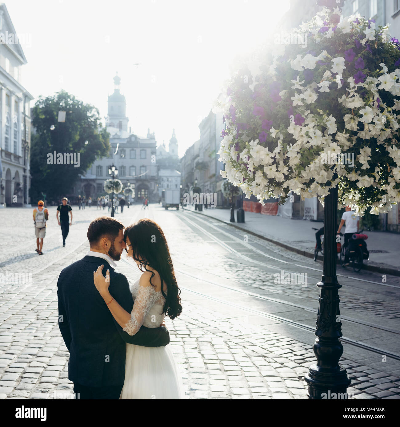 Back view of the gorgeous newlywed couple gently hugging and standing ...