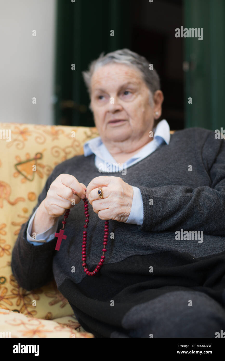 Elderly woman praying selective focus on hands and rosary, christianity ...