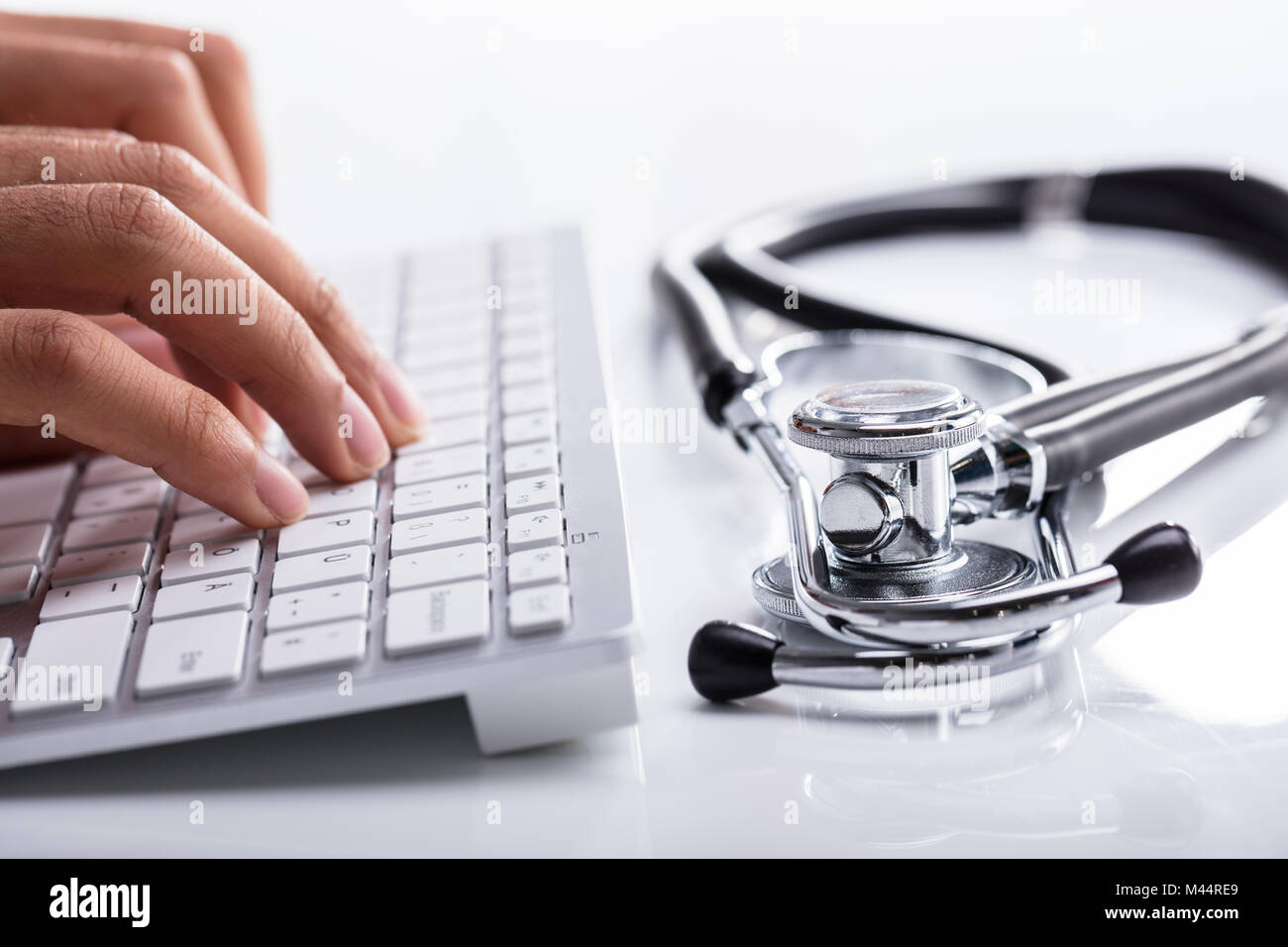 Doctor Typing On Computer Keyboard With Stethoscope On White Desk Stock ...
