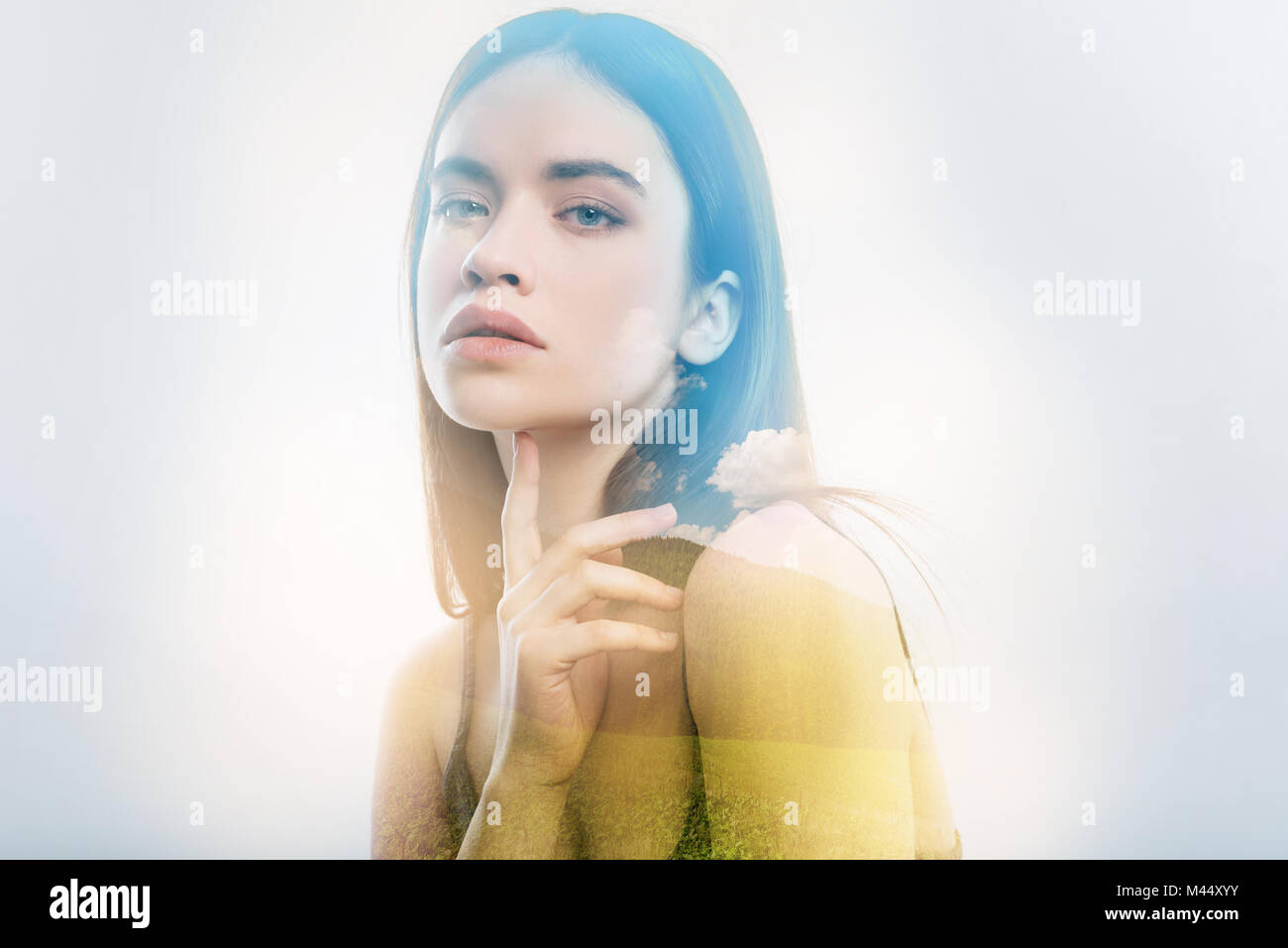 Thoughtful woman touching her chin while sitting alone Stock Photo - Alamy