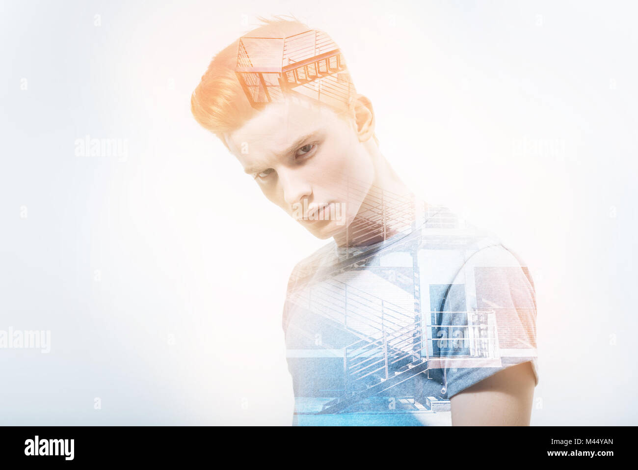 Attractive young man leaning his head and standing thoughtfully Stock ...