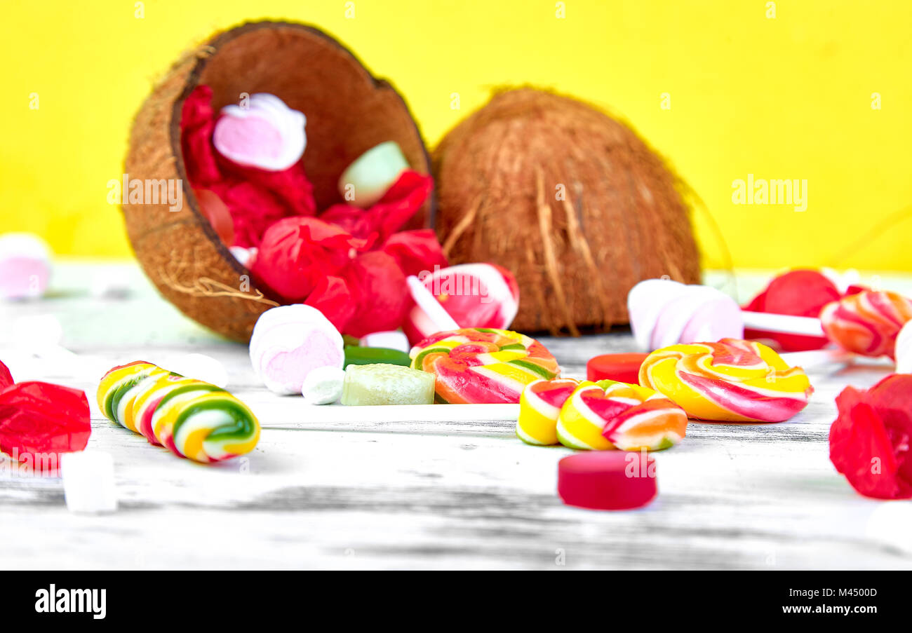 Explosion of candies from coconut on yellow paper background. Copy ...
