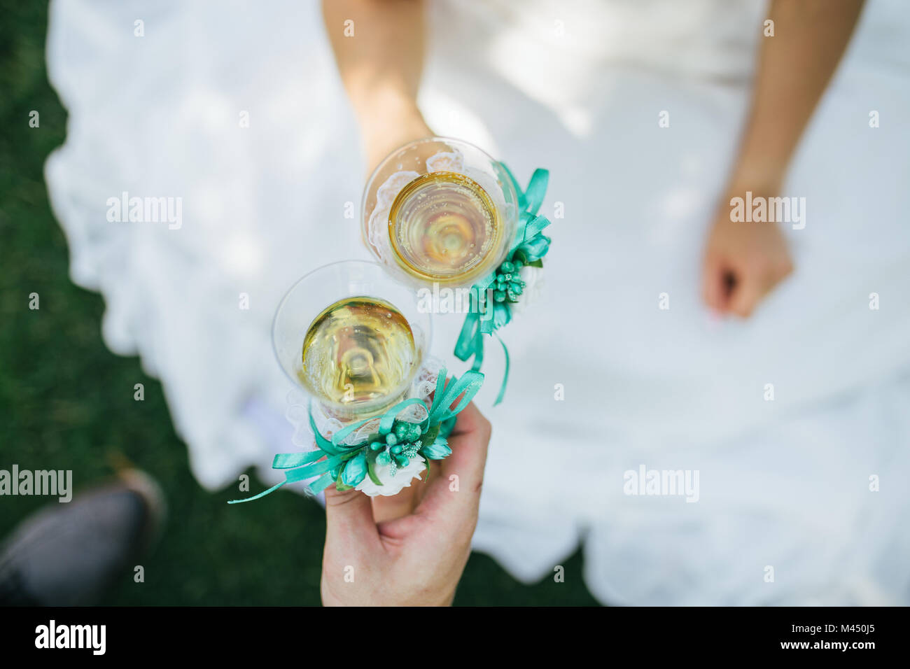 The bride and groom drink champagne on the grass Stock Photo - Alamy