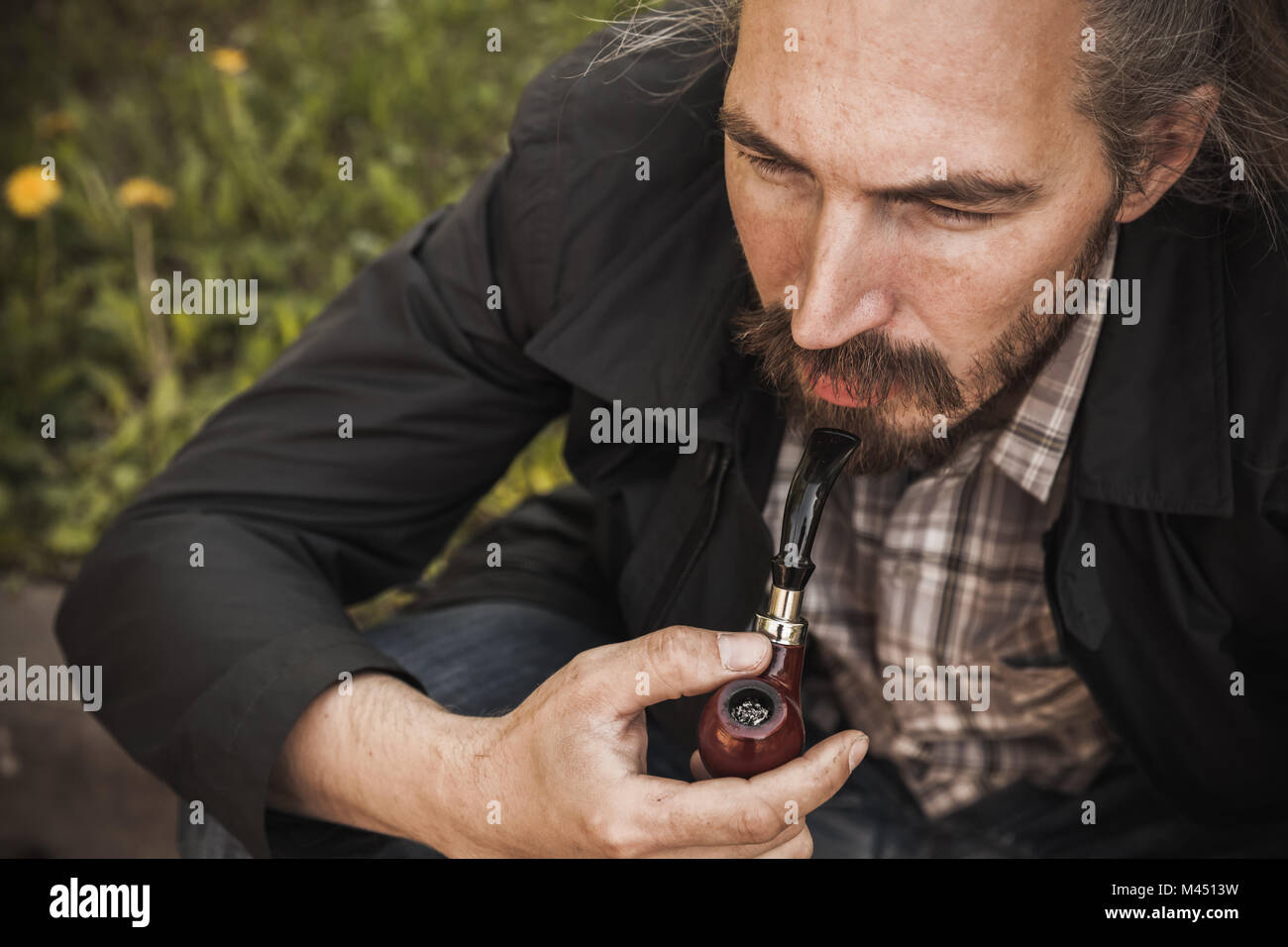 Young serious bearded man smoking pipe, close up outdoor portrait Stock ...