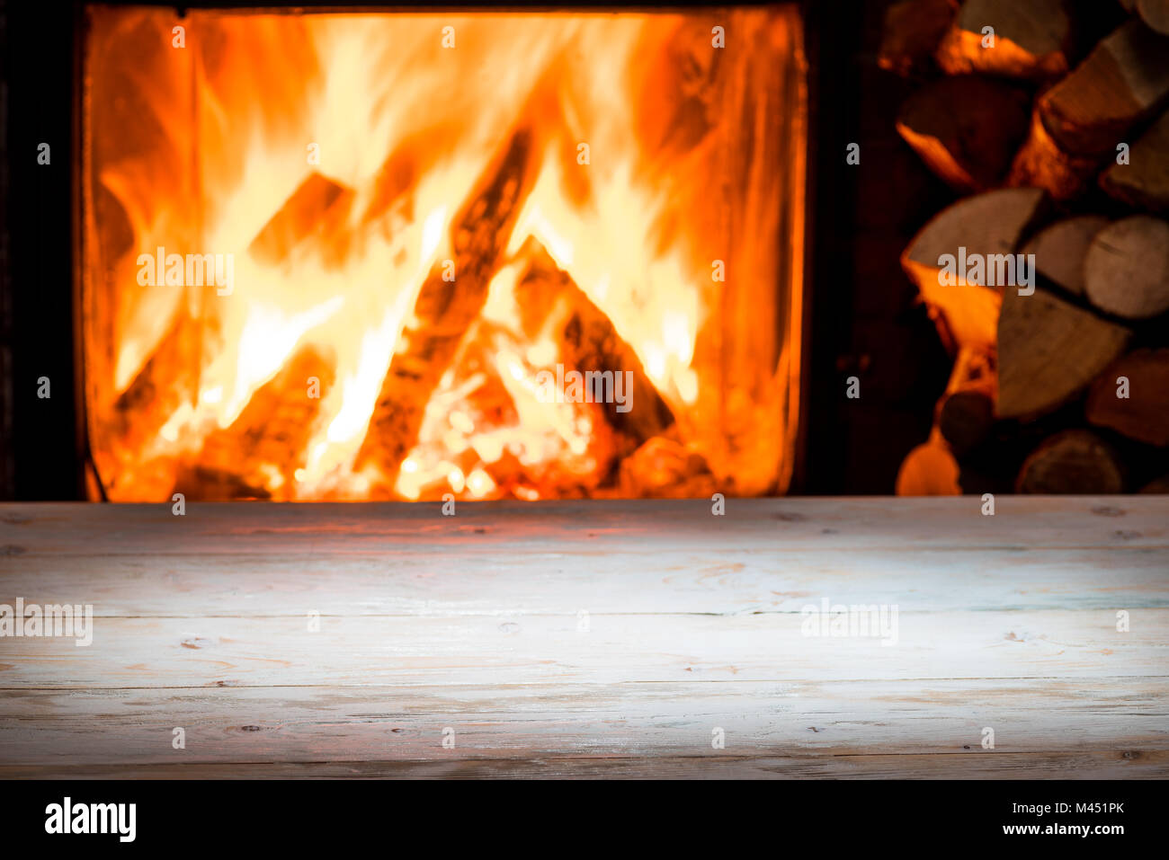 Wooden table top and burning warm fire at the background Stock Photo ...