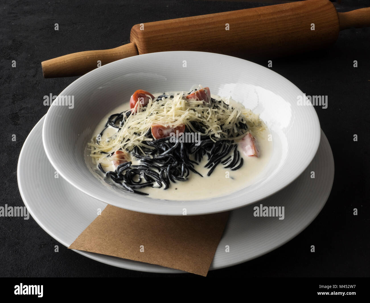 Pasta with cuttlefish ink with cheese sauce Stock Photo - Alamy