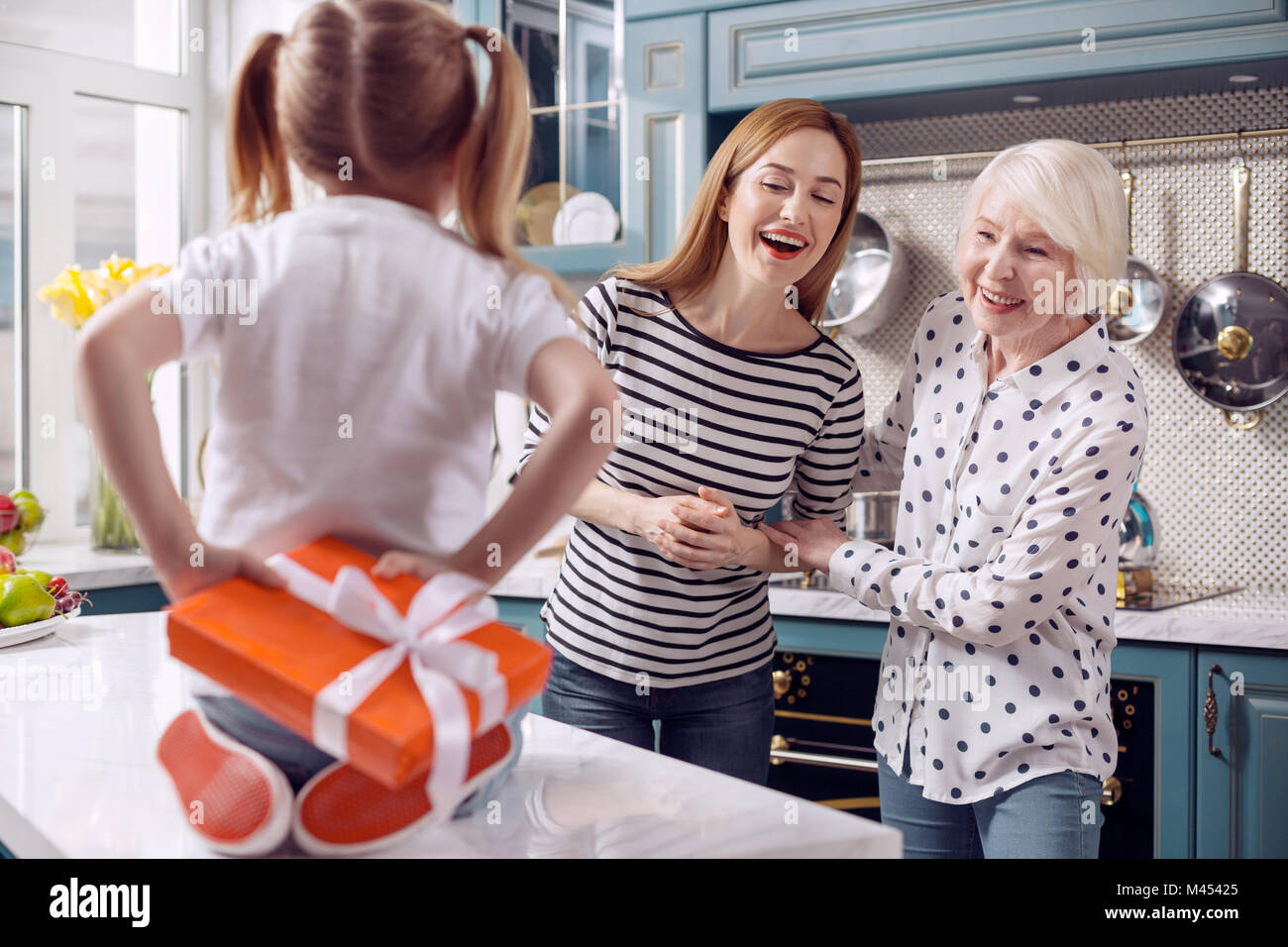 Happy women waiting for present from little girl Stock Photo - Alamy