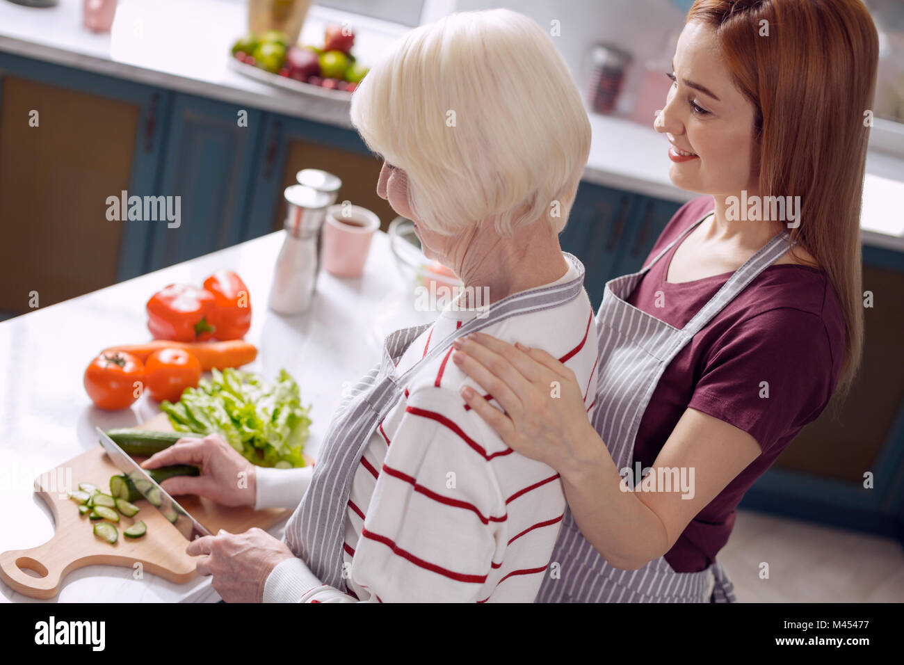 Smiling women bonding while cooking dinner together Stock Photo - Alamy