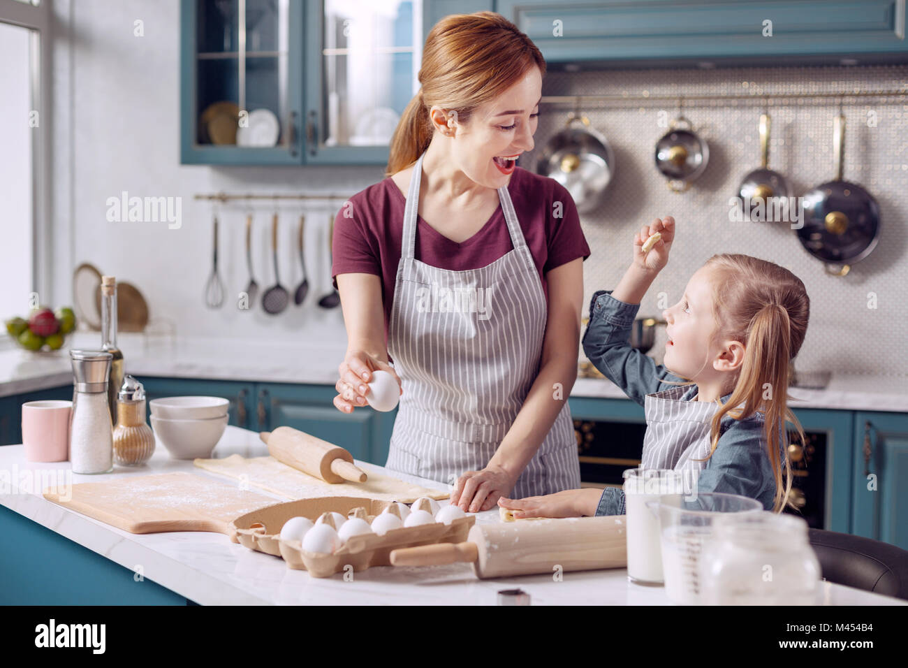 Little girl and helping her mother bake cookies Stock Photo - Alamy