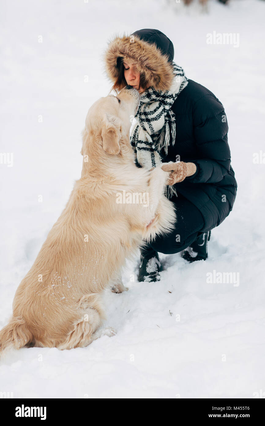 Labrador giving paw to girl in winter park in afternoon at day Stock ...
