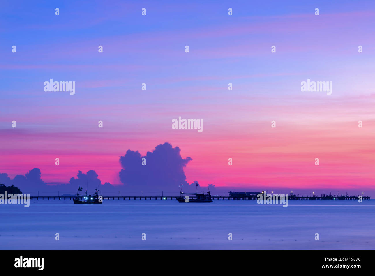 The sun sets behind a little jetty , sunset beach Stock Photo - Alamy