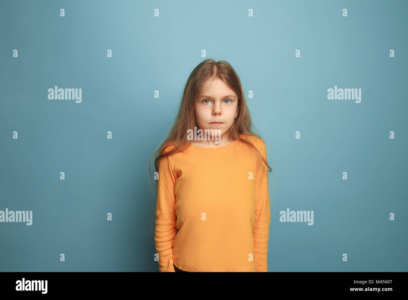 The serious teen girl on a blue background. Facial expressions and ...