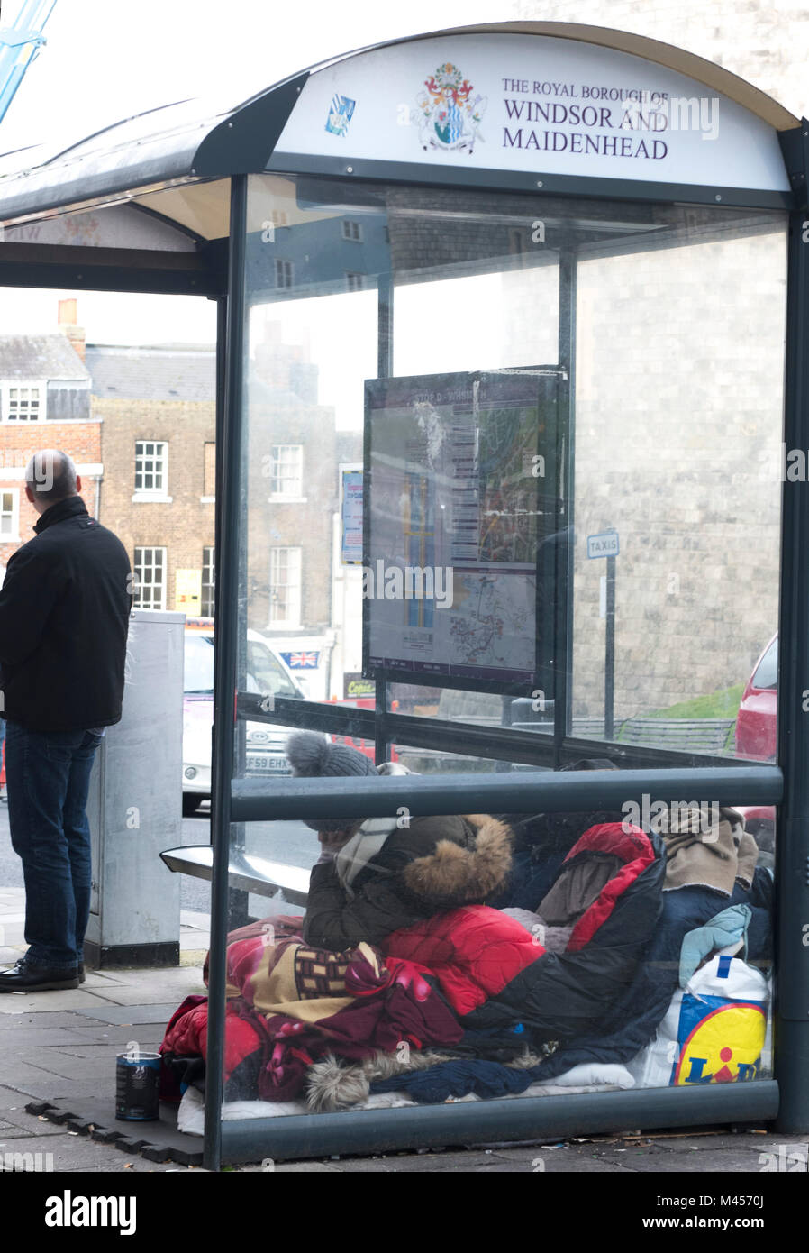 Homeless person sleeping in a bus shelter Windsor, Berks. opposite the ...