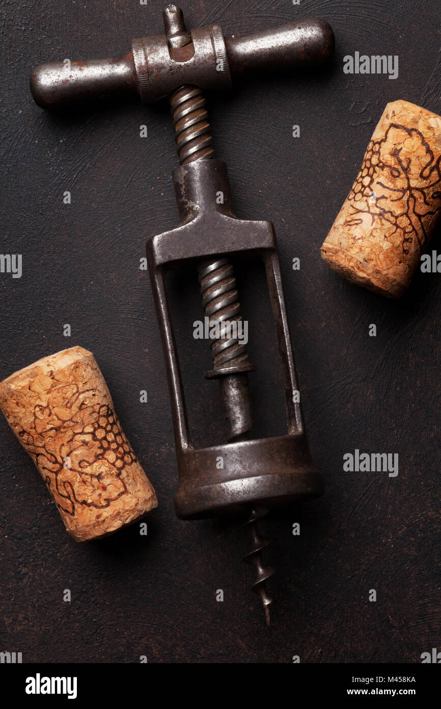 Vintage wine corkscrew and corks over stone background. Top view Stock ...