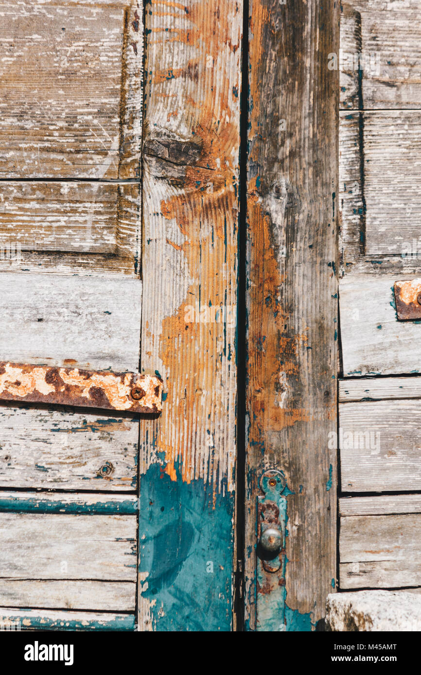 Green gray color mottled paint weathering cracked wooden door Close-up ...