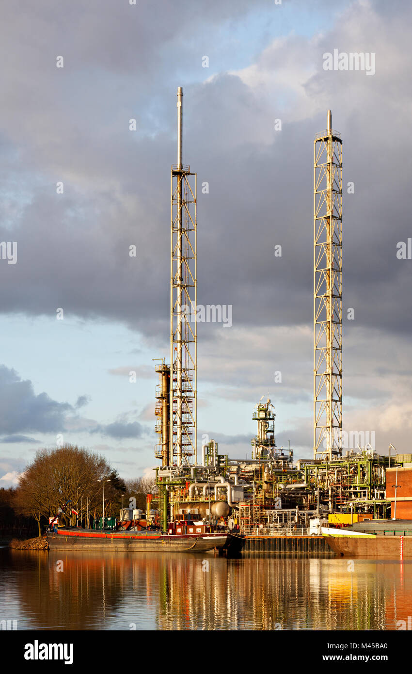 An old oil refinery with docked ships at a canal Stock Photo - Alamy