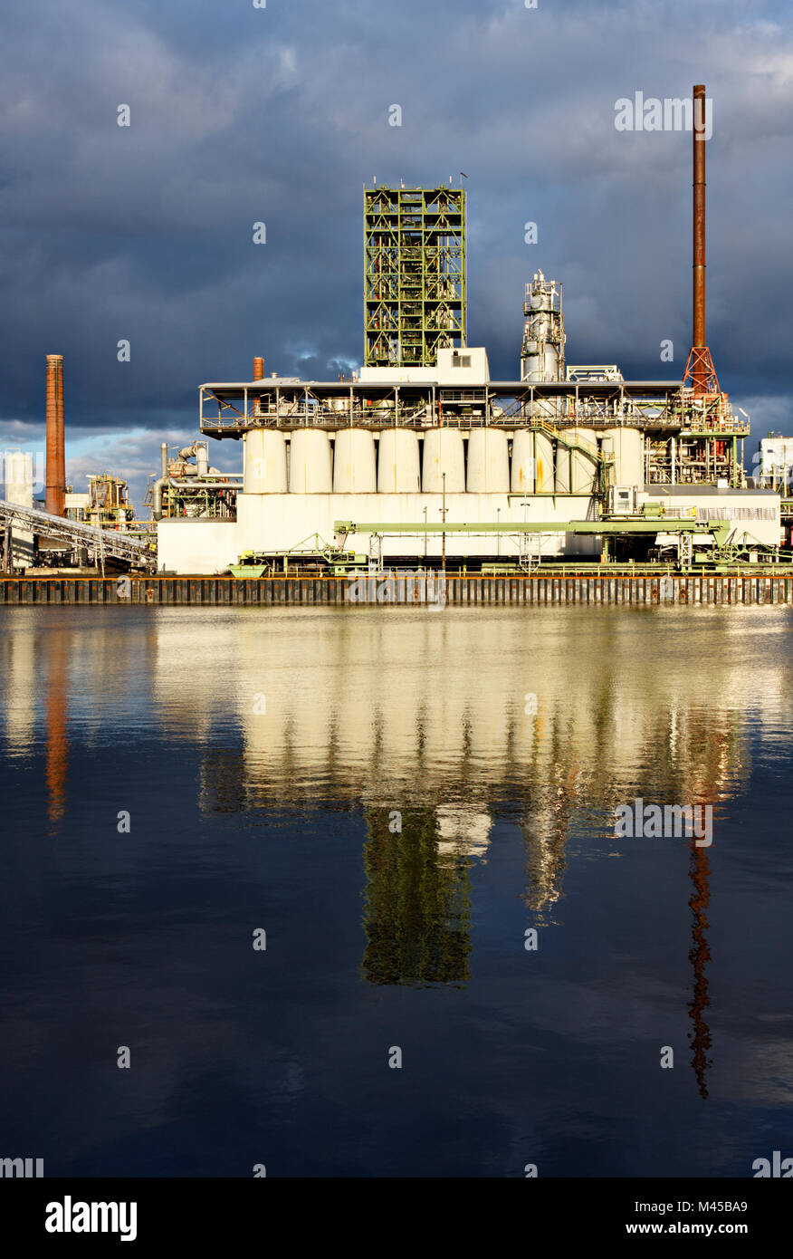 An old refinery at a canal short before sunset Stock Photo - Alamy