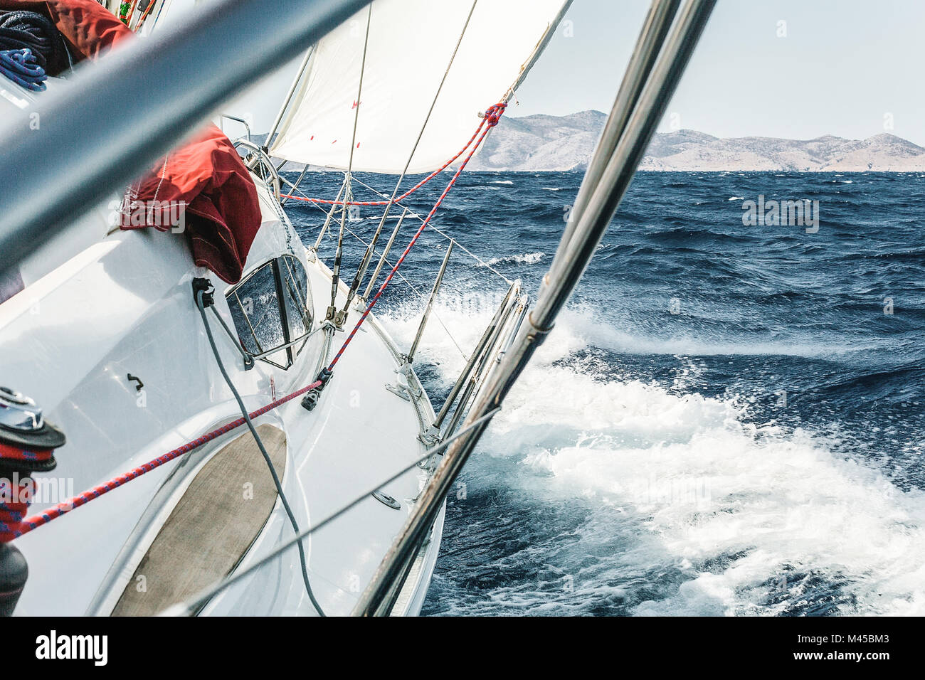Aboard view of yacht sailing through ocean waves near coast, Croatia ...