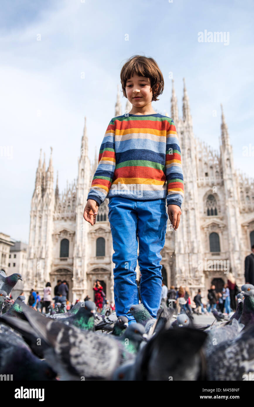 Boy amongst pigeons in Milan Cathedral square, Milan, Lombardy, Italy ...