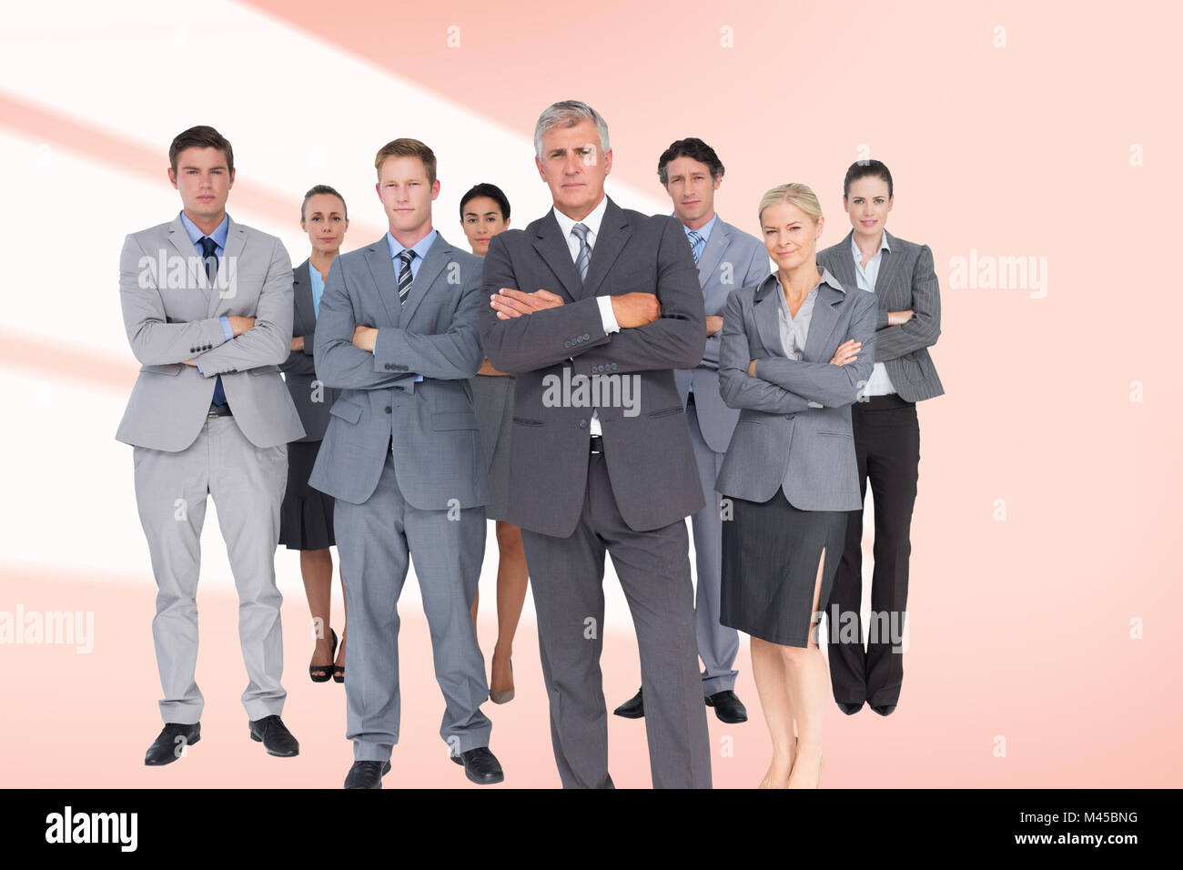Composite image of business team standing arms crossed Stock Photo - Alamy