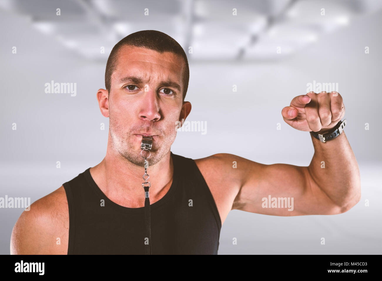 Composite image of portrait of attentive trainer blowing his whistle ...
