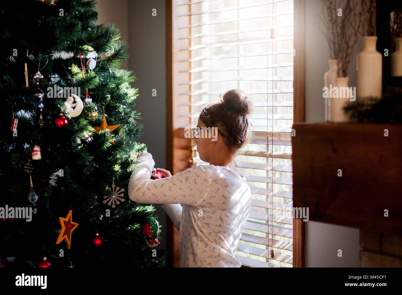 Girl putting up Christmas decorations Stock Photo - Alamy