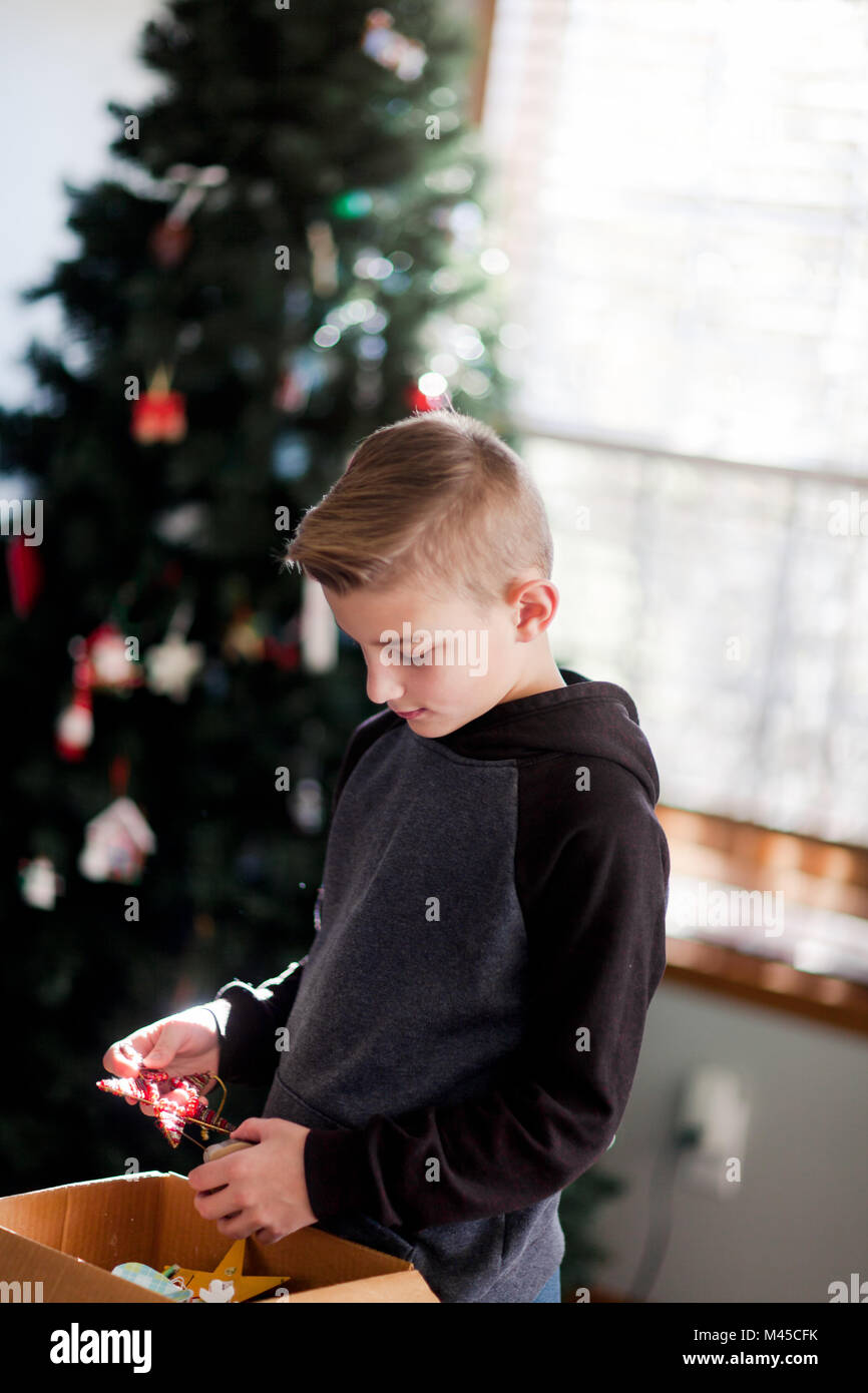 Boy putting up Christmas decorations Stock Photo - Alamy