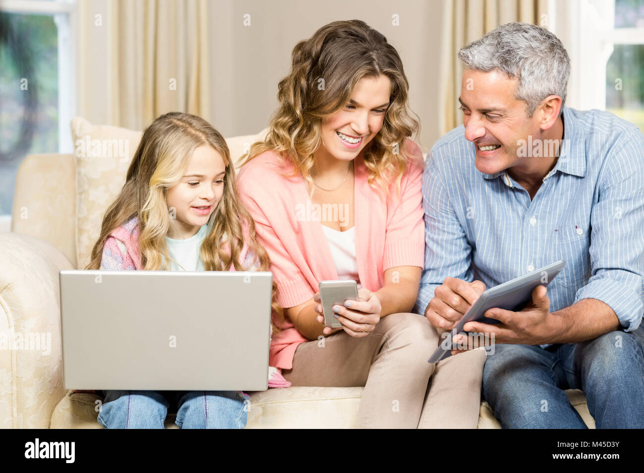 Happy family using laptop, tablet and smartphone Stock Photo - Alamy