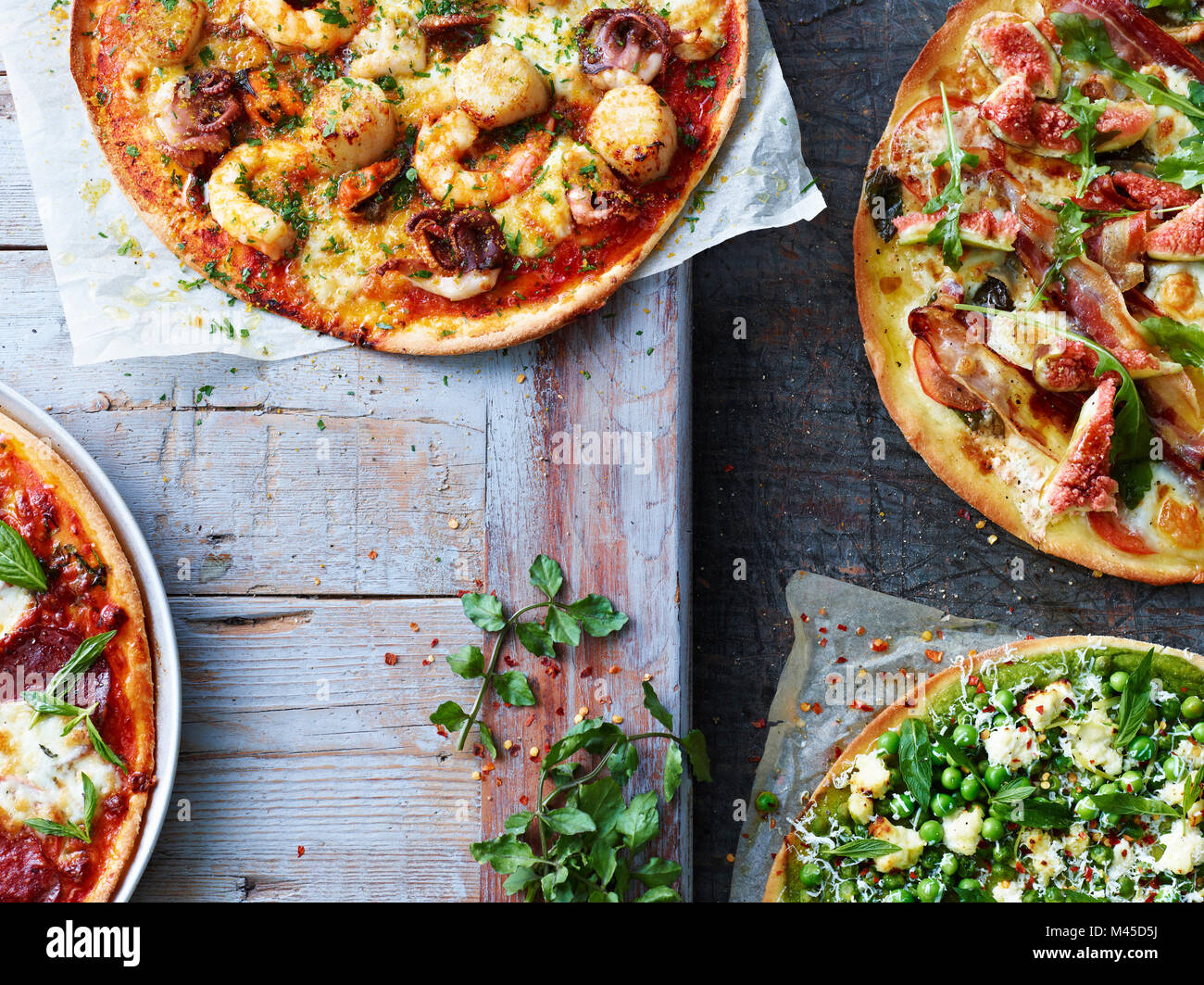 Four fresh pizzas, cropped overhead view Stock Photo - Alamy