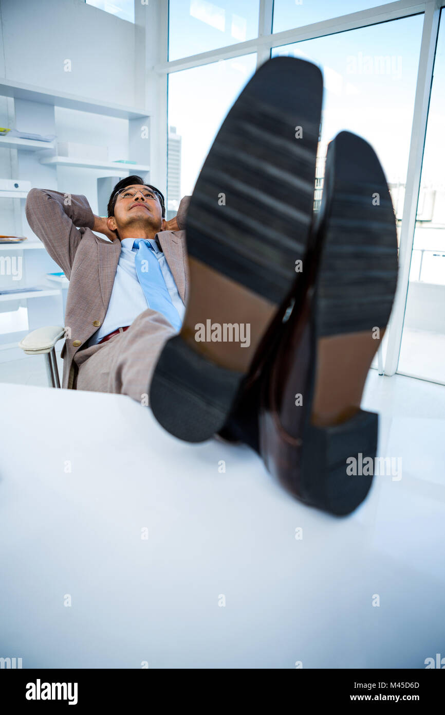 Successful businessman relaxing with his feet on his desk Stock Photo ...