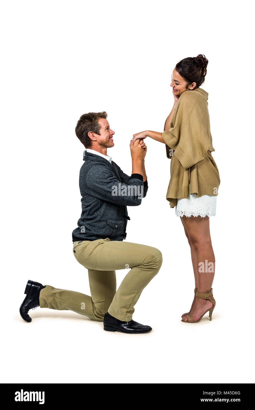 Handsome man proposing beautiful woman while kneeling Stock Photo - Alamy