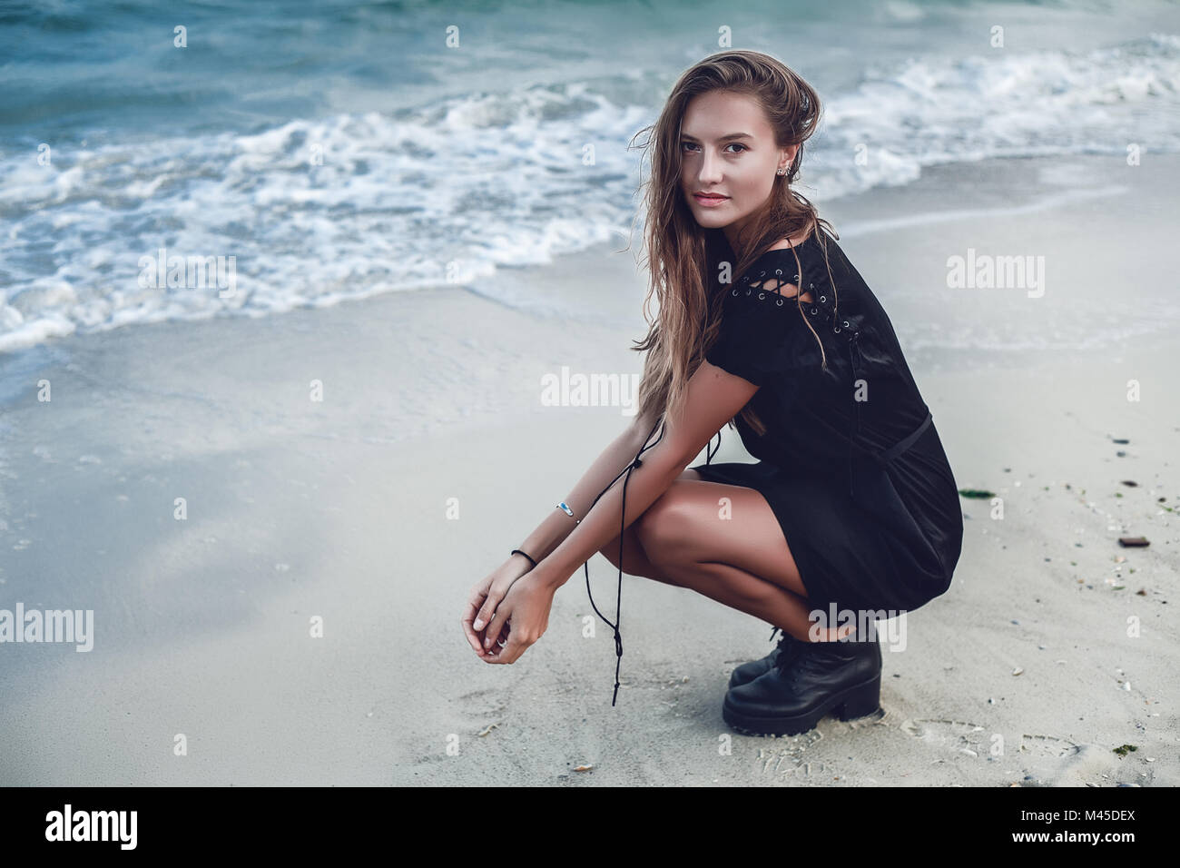 Portrait crouching woman wearing black hi-res stock photography and ...