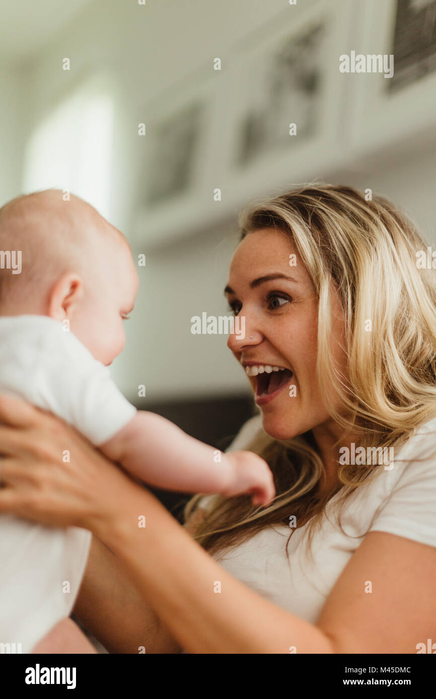 Mother smiling at baby daughter face to face Stock Photo - Alamy