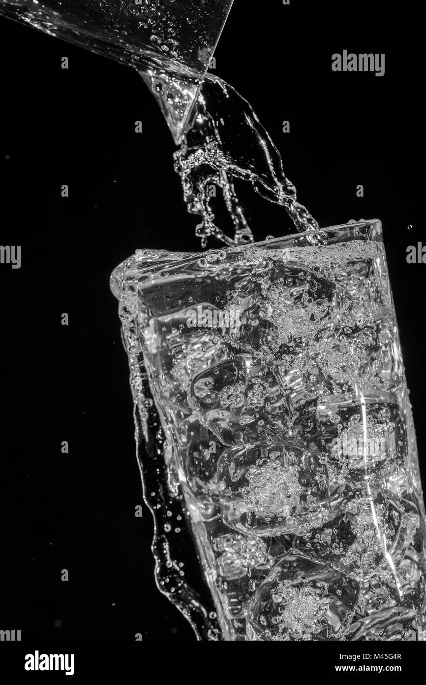 sparkling water overflow over ice cubes Stock Photo - Alamy